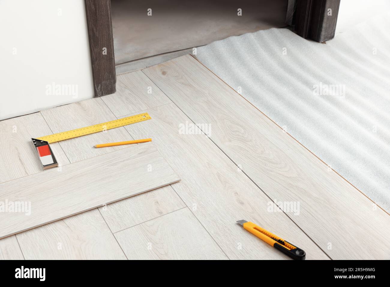 Repair tools and parquet planks on floor in room Stock Photo - Alamy