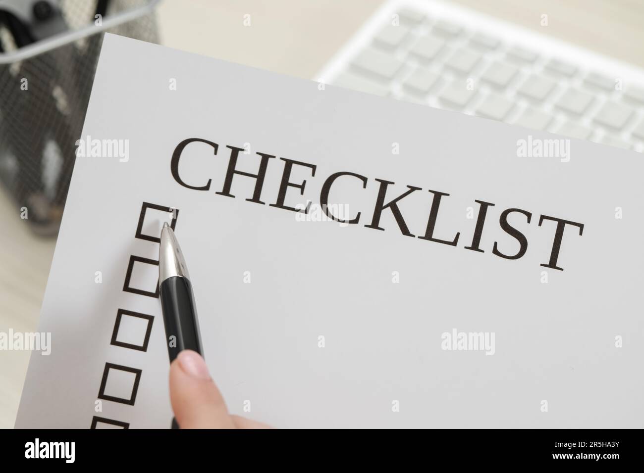 Woman filling Checklist with pen at workplace, closeup Stock Photo - Alamy