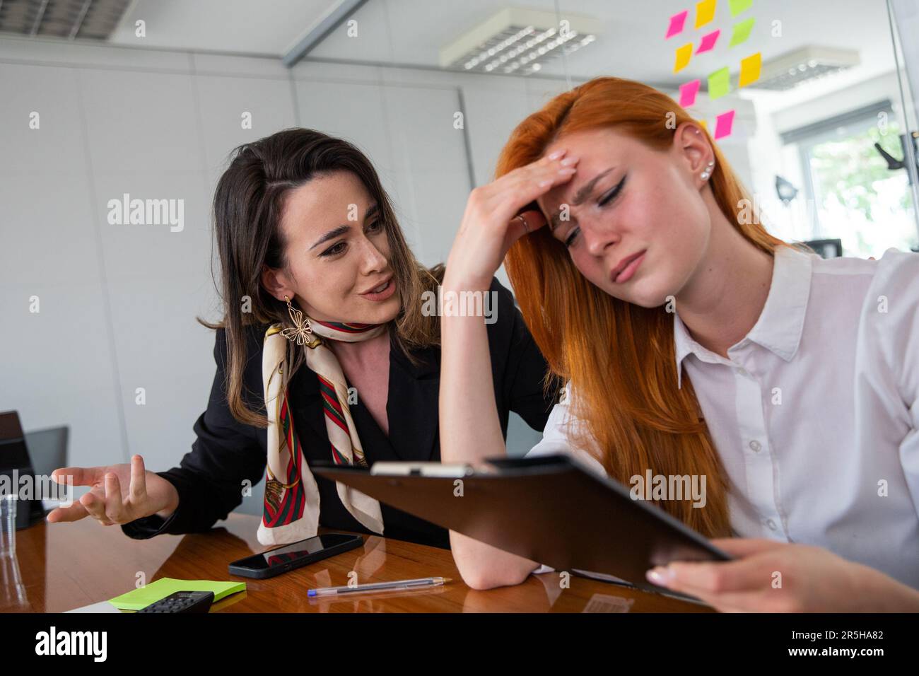 A businesswoman tries to comfort her colleague who is sad and stressed ...