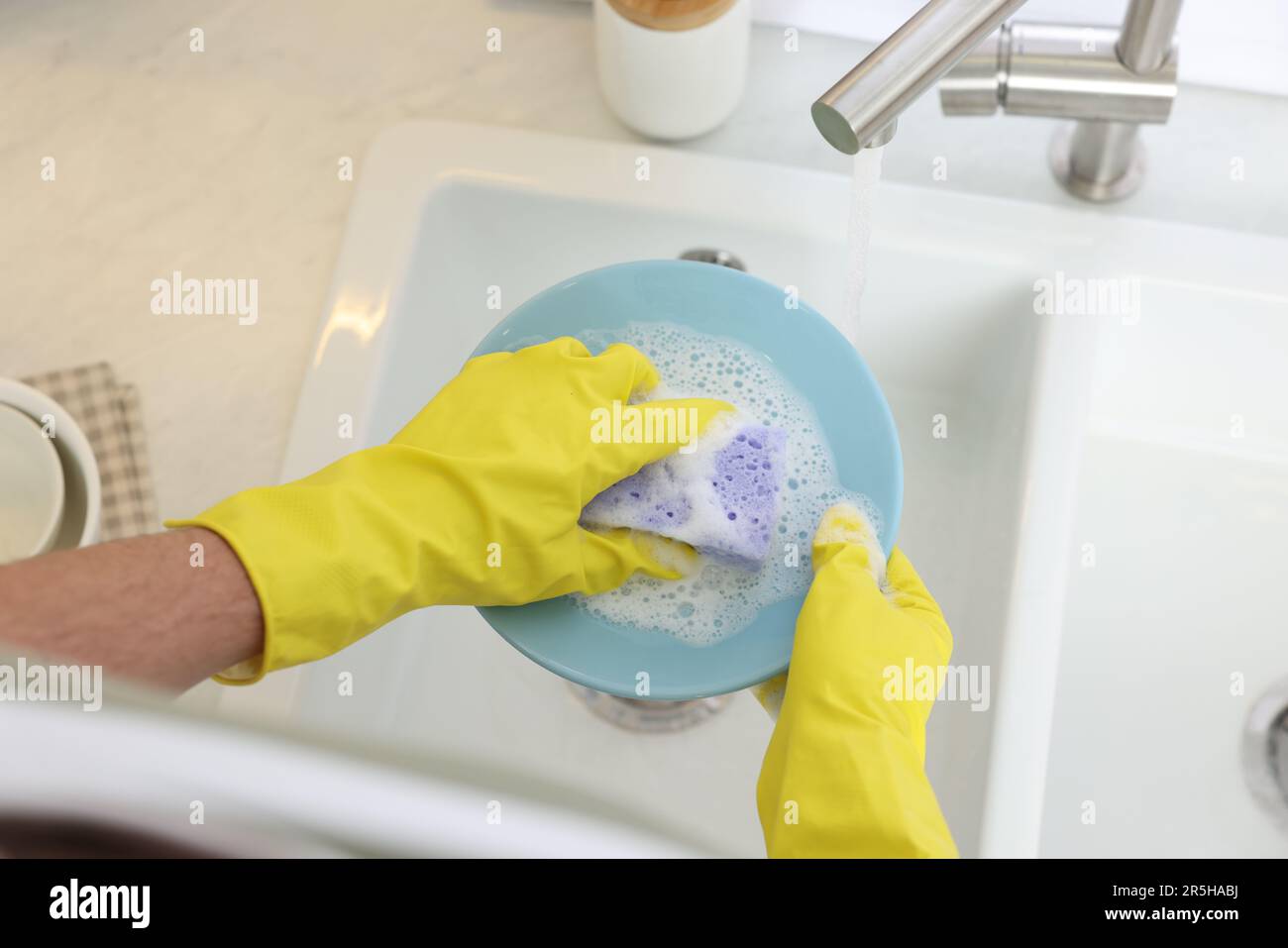 Man washing plate in kitchen sink, above view Stock Photo - Alamy