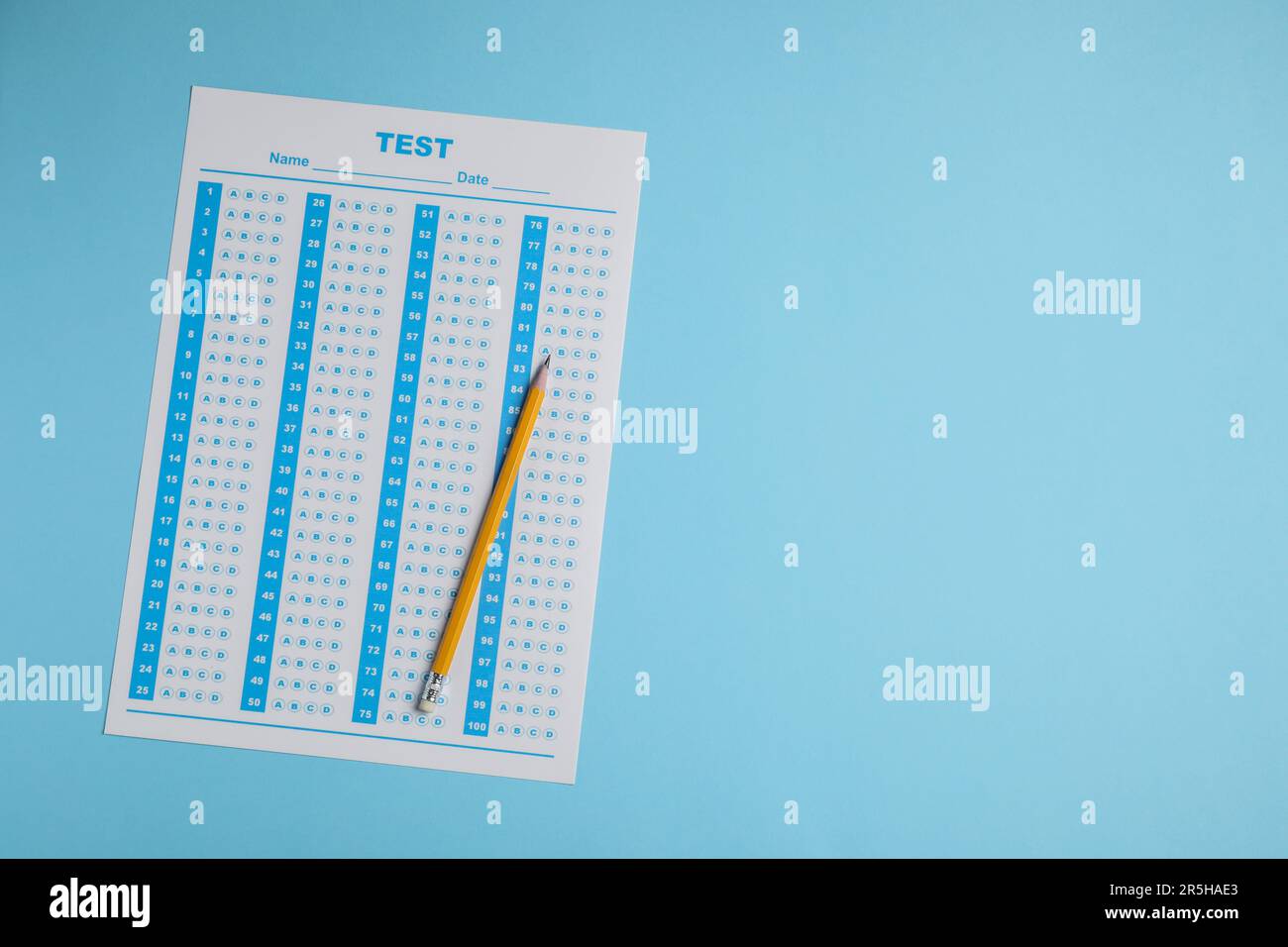 Answer sheet and pencil on light blue background, top view with space ...