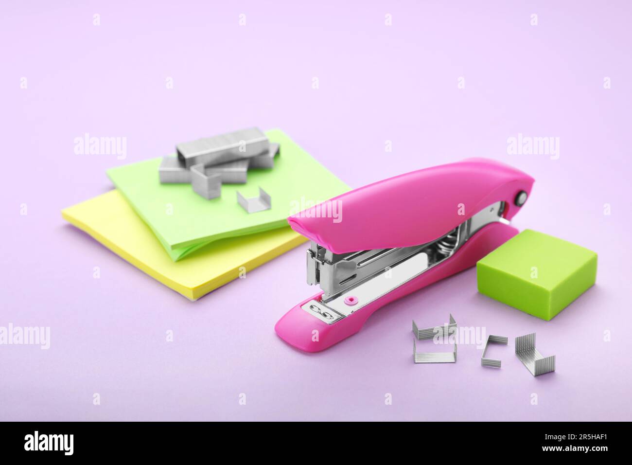 New bright stapler with stationery on light grey background Stock Photo ...