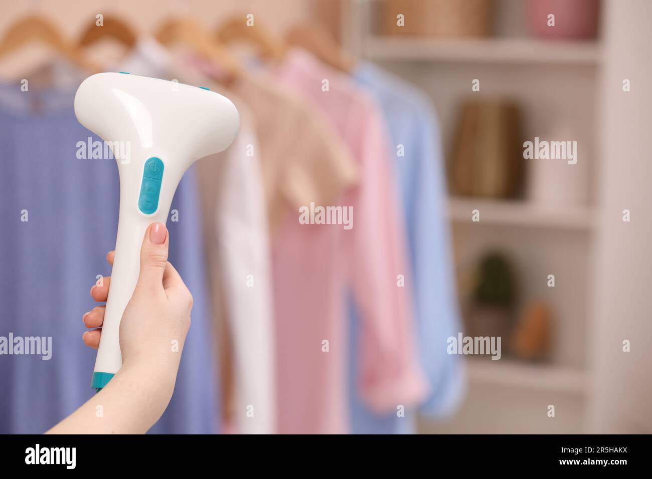 Woman with modern steam iron at home, closeup. Space for text Stock ...
