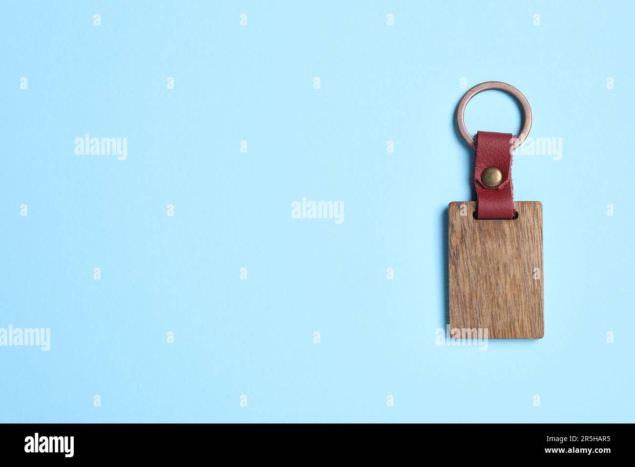 Wooden keychain with Ukrainian coat of arms on light blue background ...