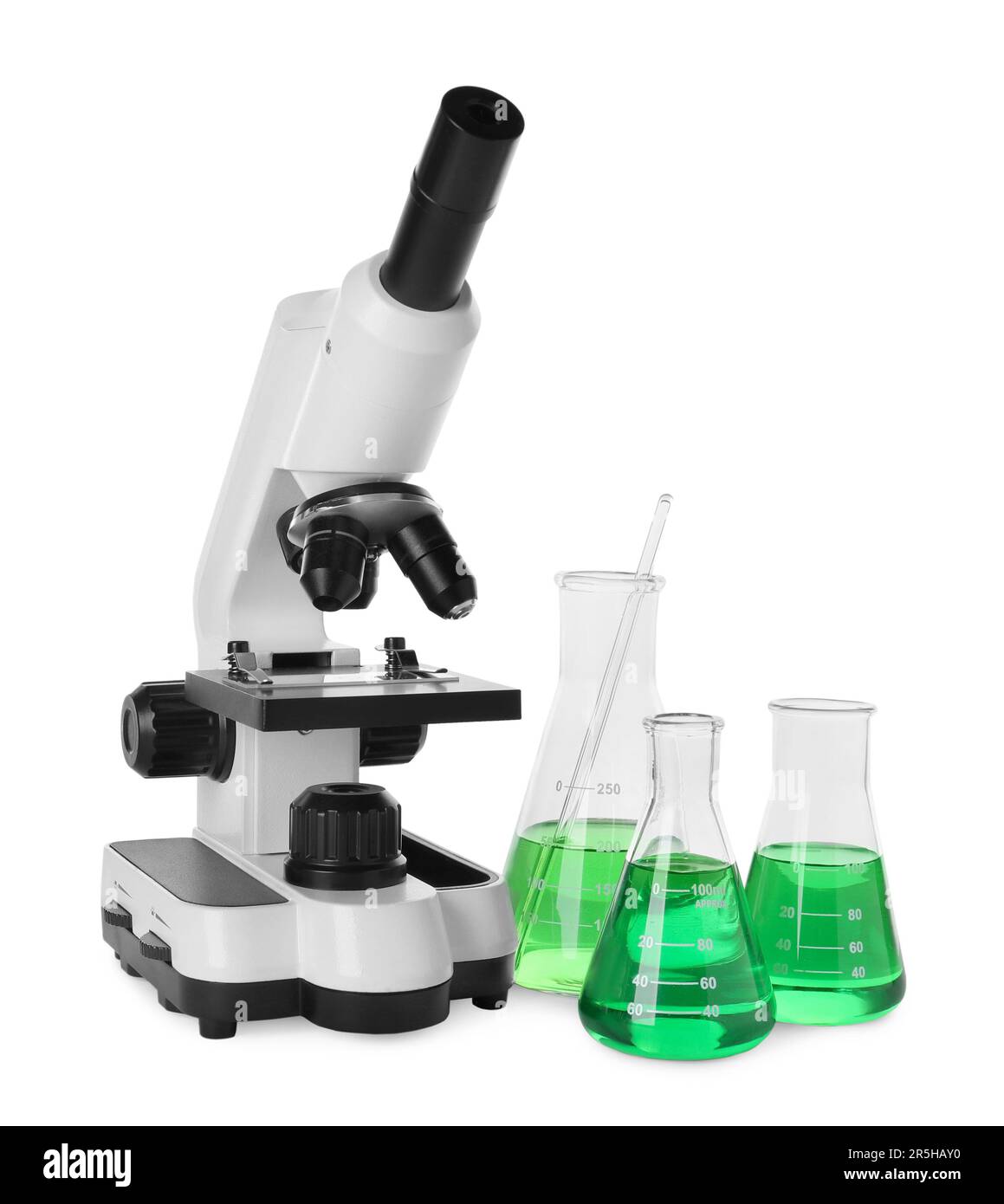 Laboratory glassware with green liquid and microscope isolated on white ...