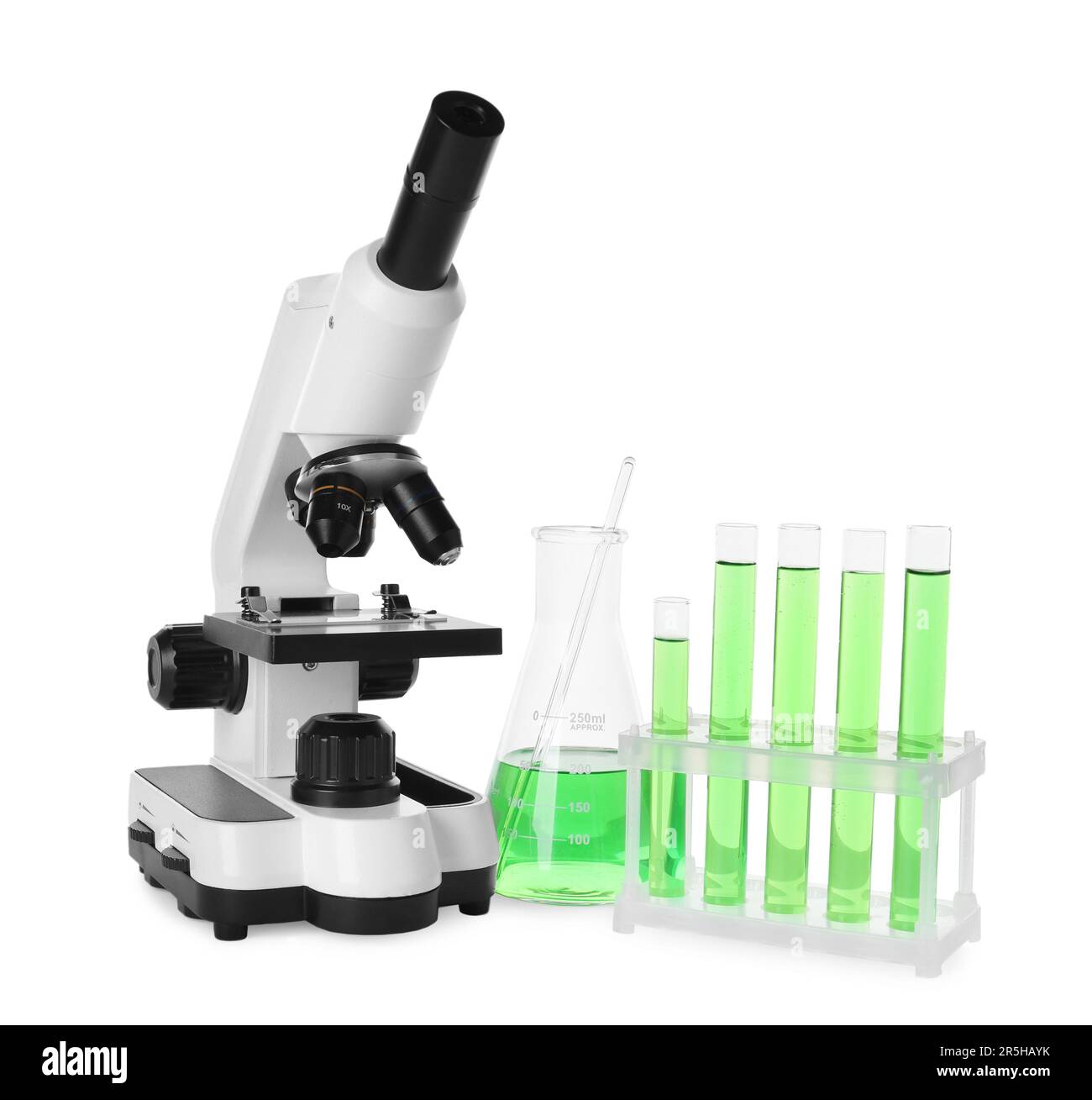 Laboratory glassware with green liquid and microscope isolated on white ...