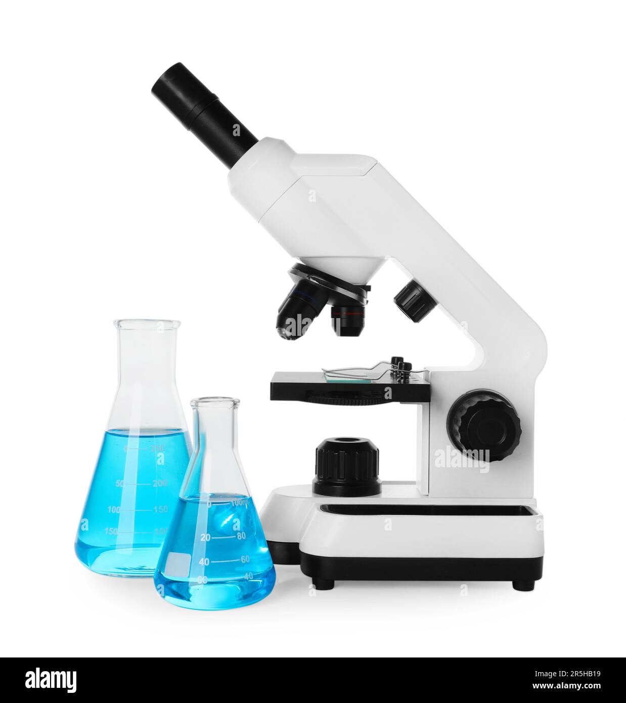 Laboratory glassware with light blue liquid and microscope isolated on ...