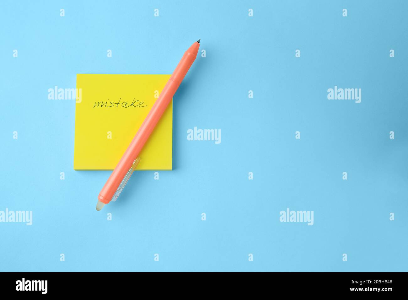 Paper notes with word Mistake and erasable pen on light blue background ...
