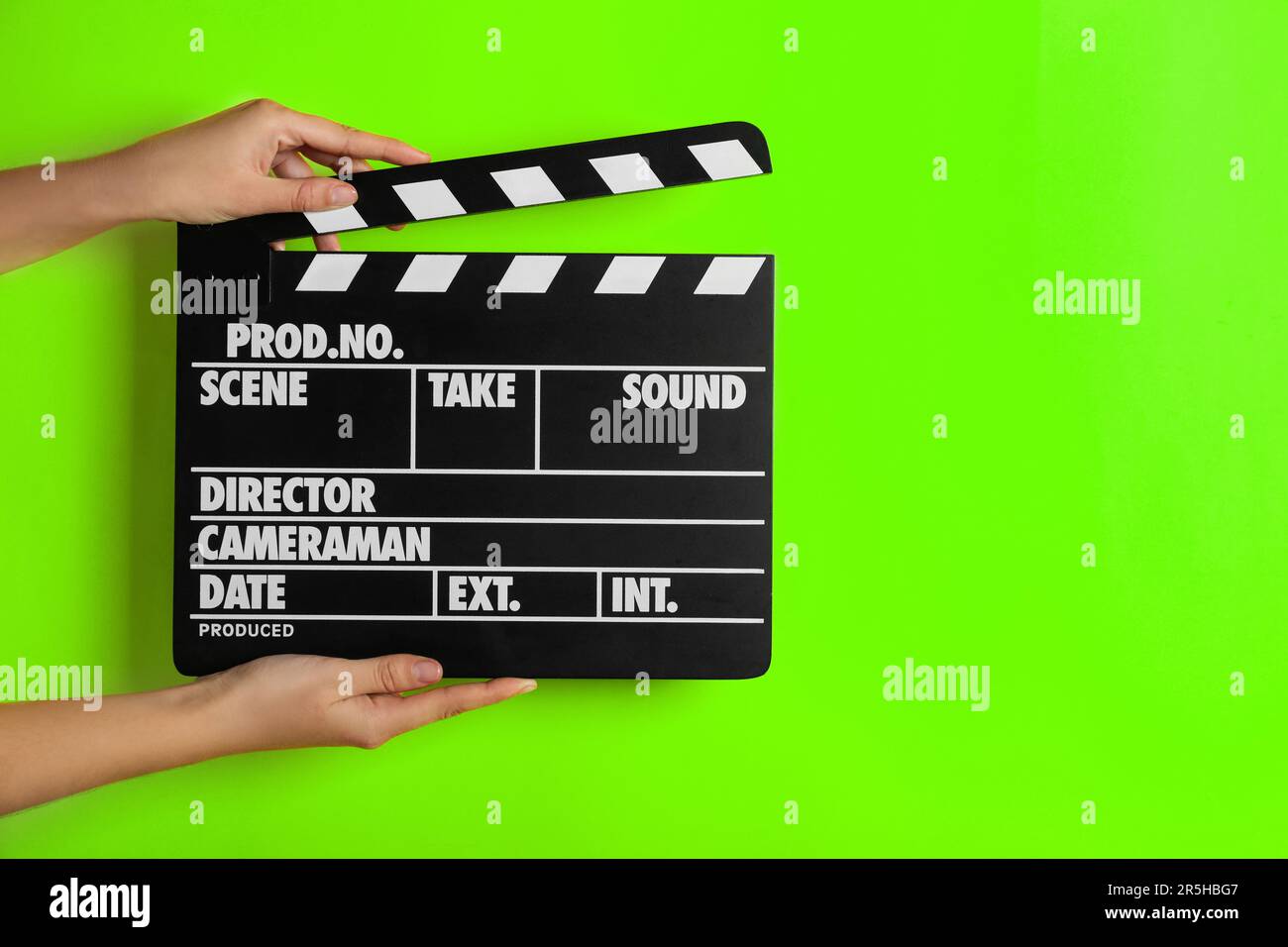 Second assistant camera holding clapper board against chroma key ...