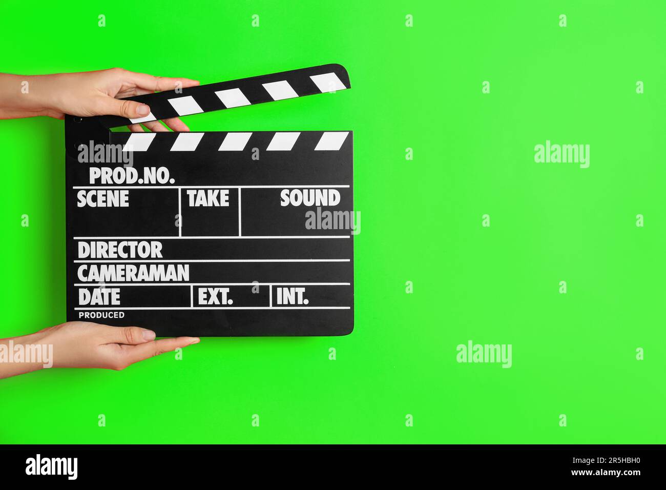 Second assistant camera holding clapper board against chroma key ...