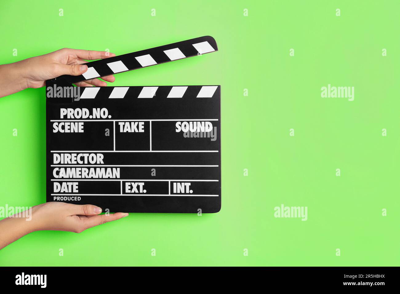 Second assistant camera holding clapper board against chroma key ...