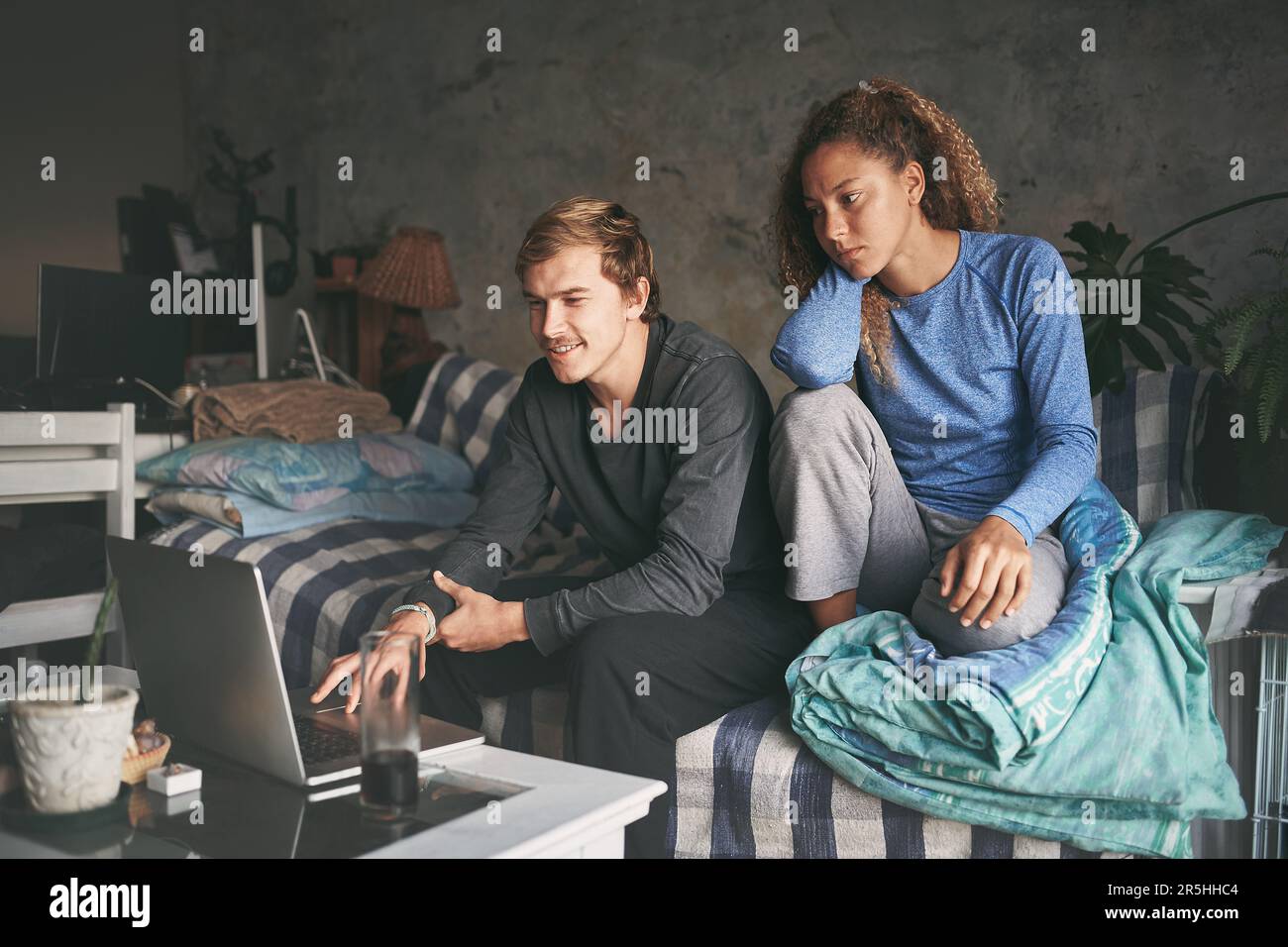 Lazy weekends are for lounging around. a young couple using a laptop on ...