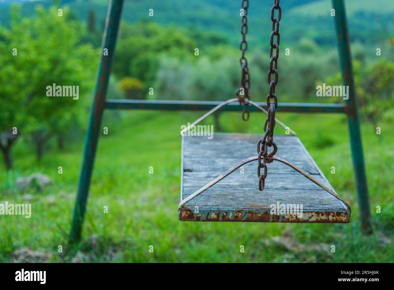 Side view of empty old wooden swing set seat Stock Photo - Alamy