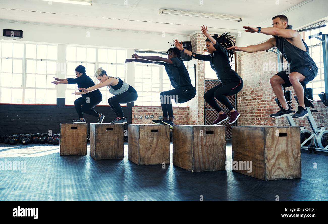 Launch and landing. a focused group of young people jumping onto crates ...