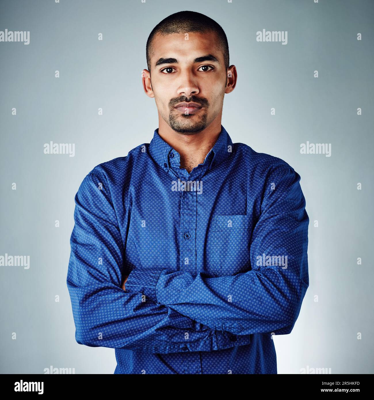 Take what you do seriously. a young businessman posing against a grey ...
