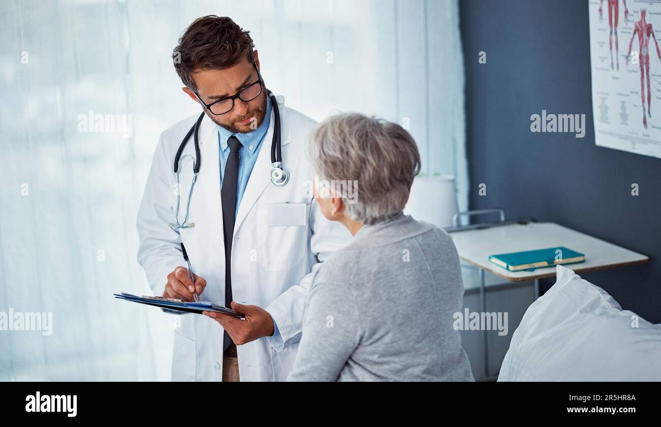 Please describe your symptoms further. a doctor writing notes while ...