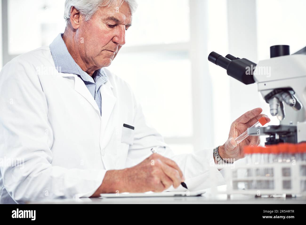 Research is part of the job. a focused elderly male scientist holding ...