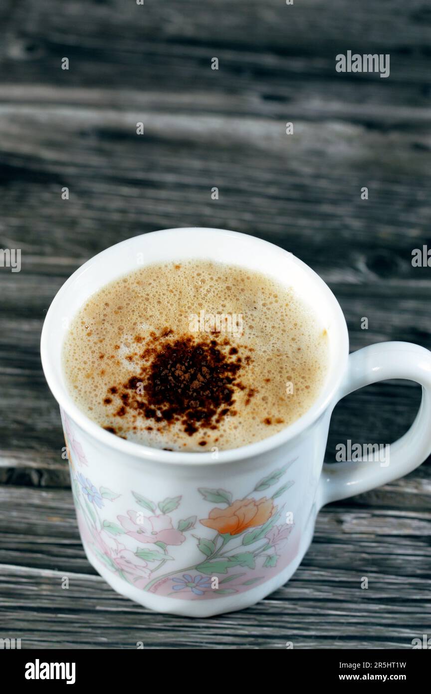 A mug of cappuccino topped with creamy froth and coffee, an espresso ...