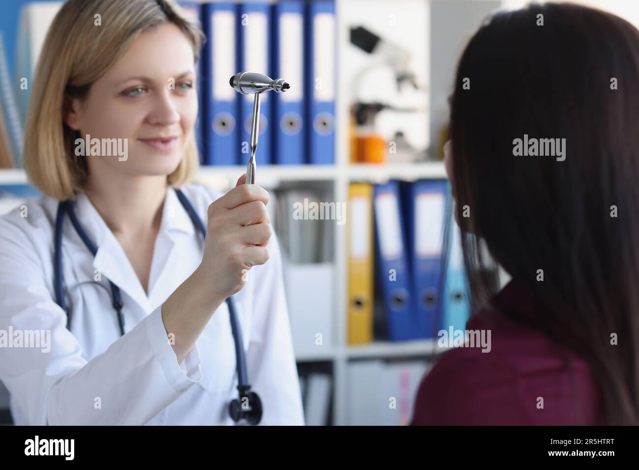 Female neurologist examines patient with hammer in private clinic Stock ...
