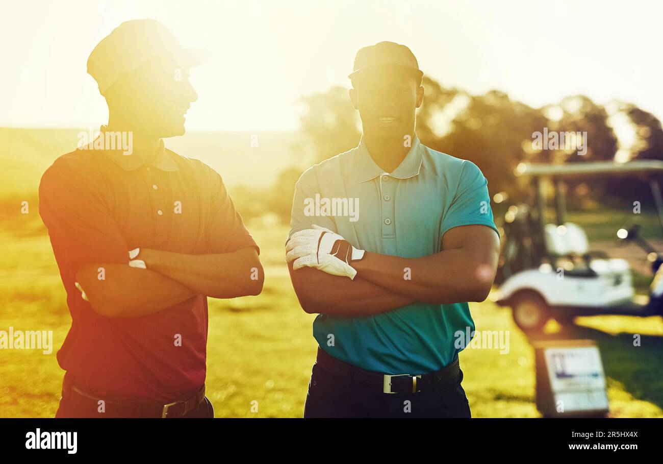 The dress code of champions. two friends standing together on a golf ...