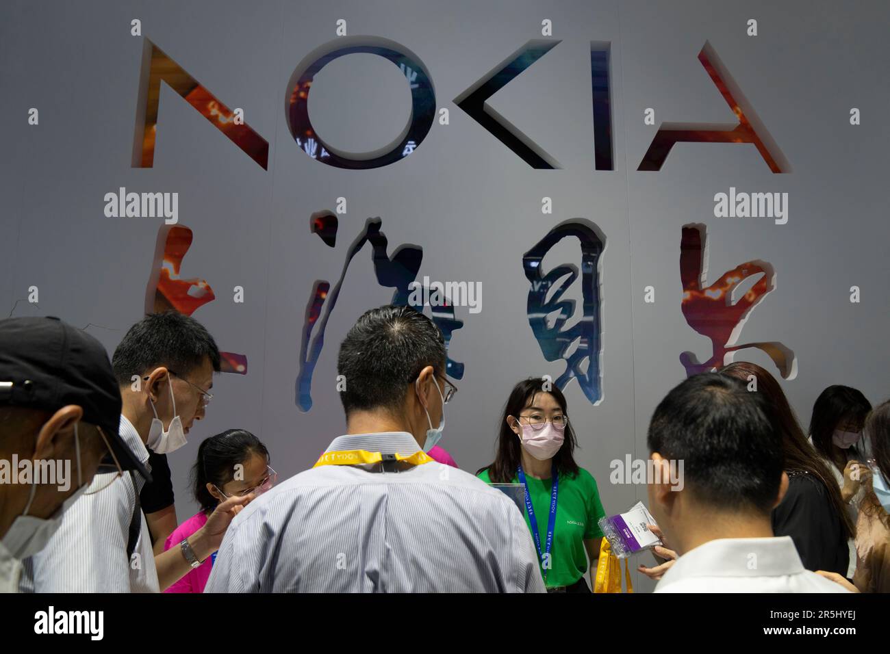 Visitors talk to staff members at a display for technology firm Nokia ...