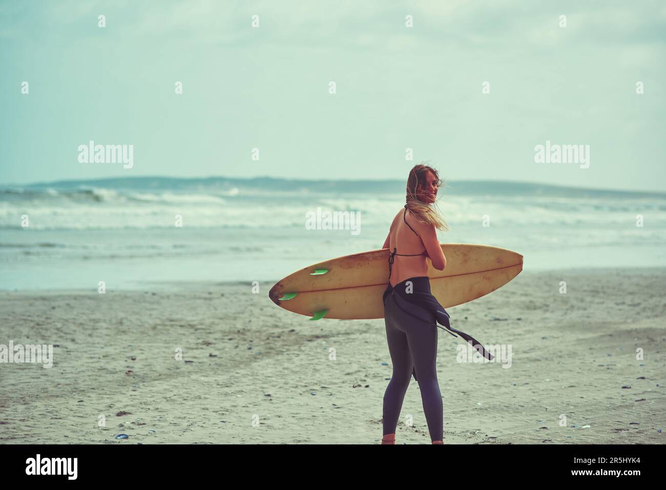 Surfing vibes. a beautiful young woman going for a surf at the beach ...