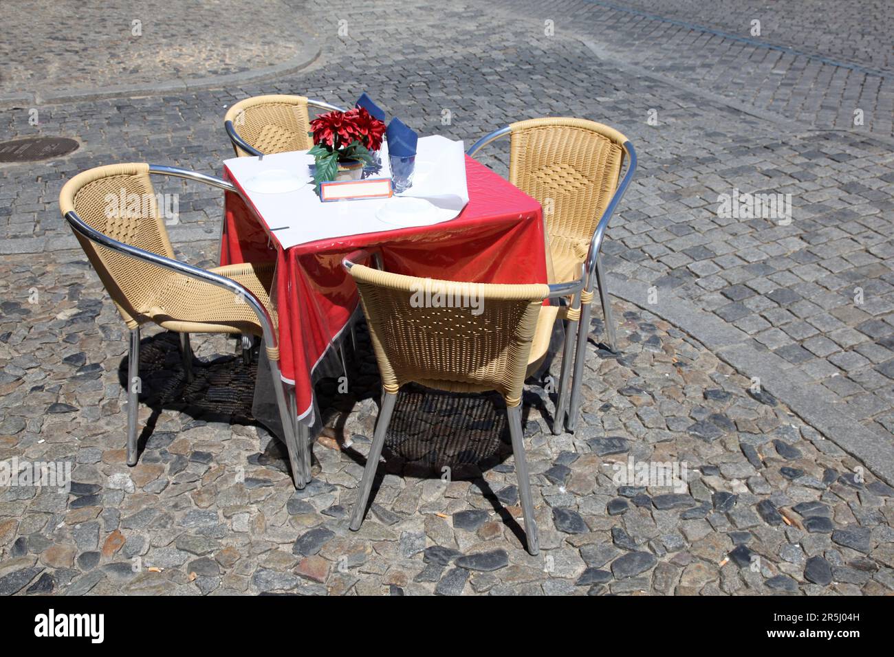 An outdoors Cafe Table with four chairs waiting for customers to arrive ...