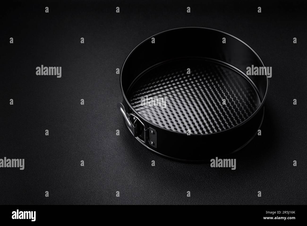 Round metal black detachable baking dish for baking on a dark concrete ...