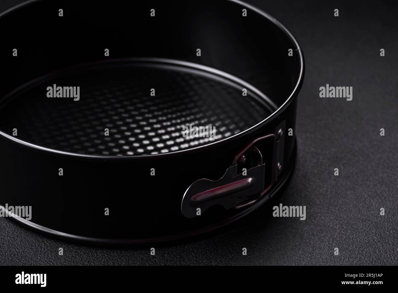 Round metal black detachable baking dish for baking on a dark concrete ...