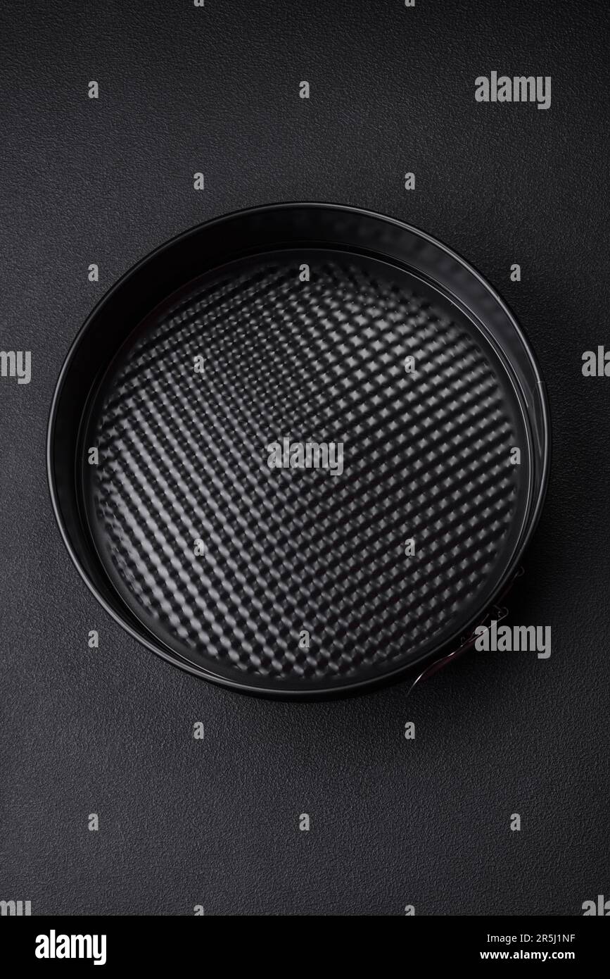 Round metal black detachable baking dish for baking on a dark concrete ...