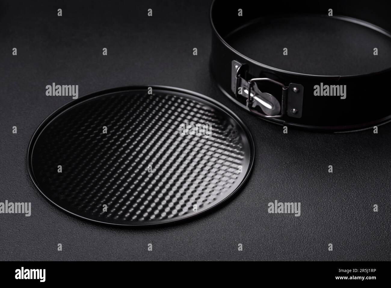 Round metal black detachable baking dish for baking on a dark concrete ...