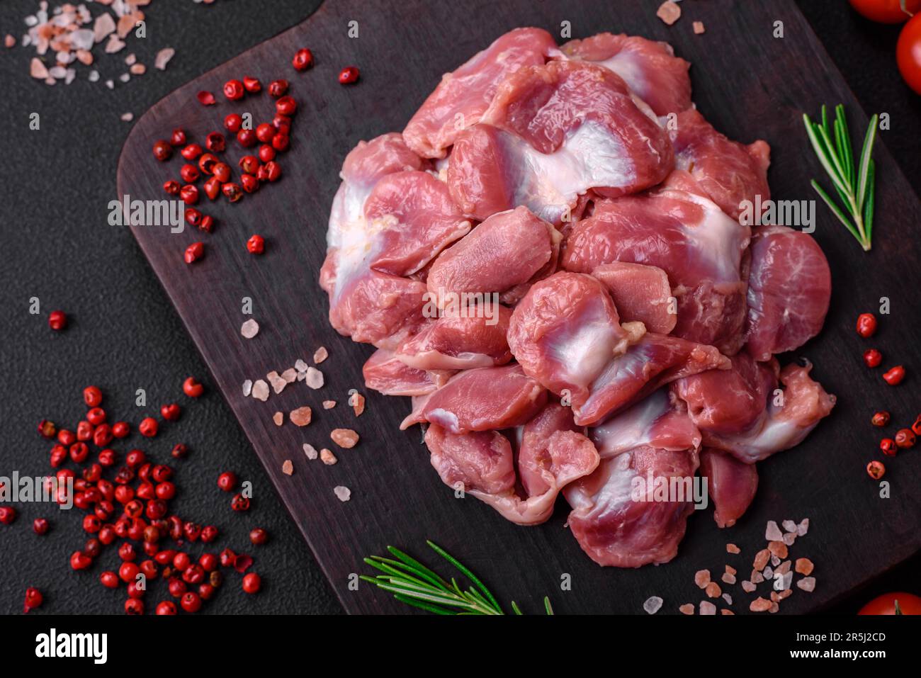 Raw chicken or turkey gizzards with salt, spices and herbs on a ...