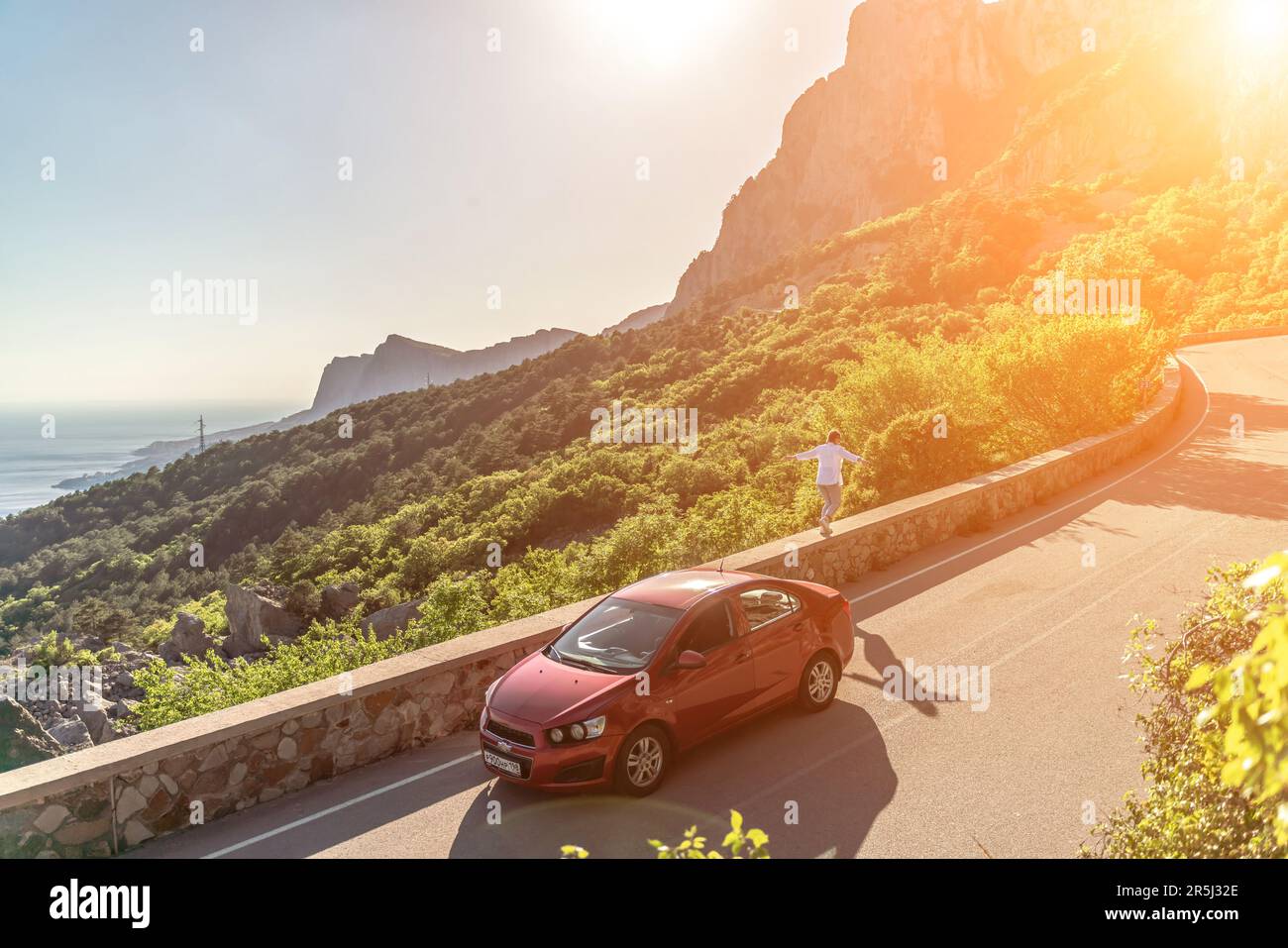 Mountain road woman. She walks along a parapet road in the middle of a ...