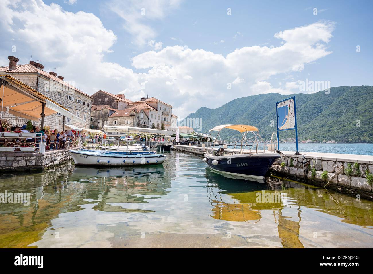Small boats moored in Perast next to a resturant serving tourists local ...