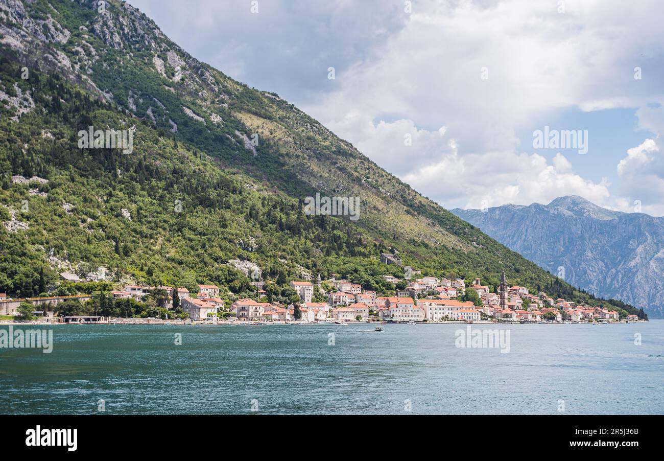 The pretty village of Perast nestled at the foot of a rugged mountain ...