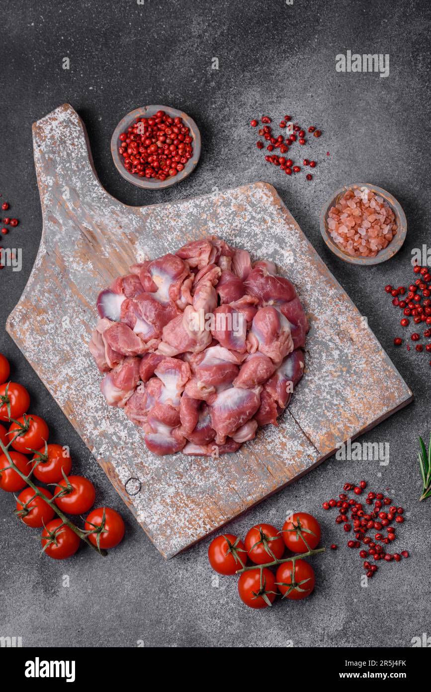 Raw chicken or turkey gizzards with salt, spices and herbs on a ...