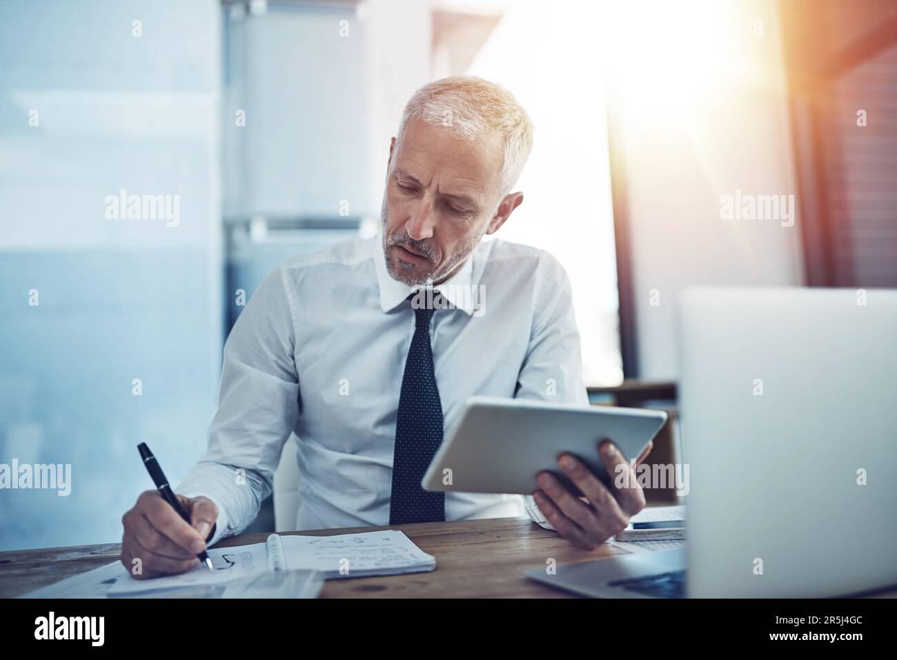 Keeping track of facts and figures. a businessman sitting at his desk ...