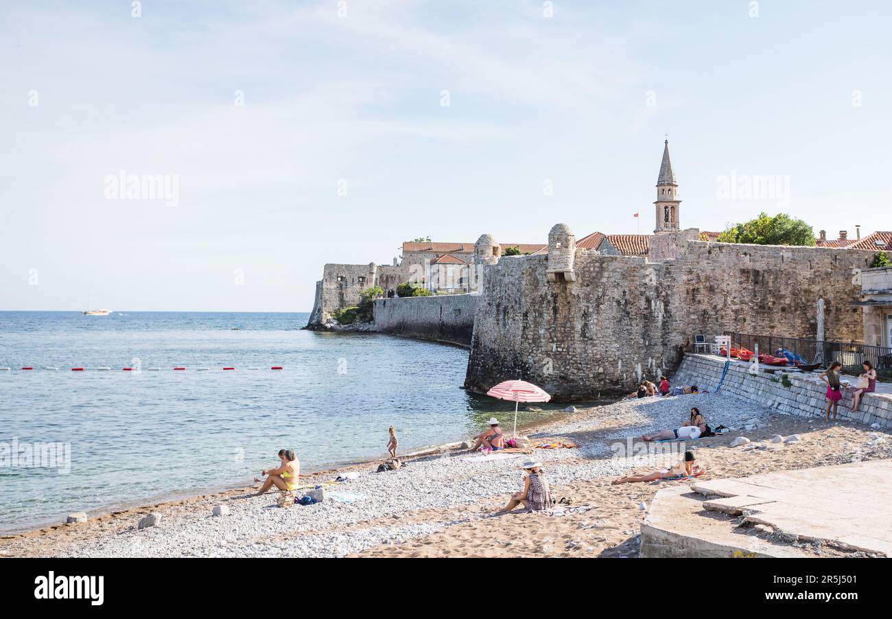 People enjoy the sunshine on the small Pizana Beach next to the old ...
