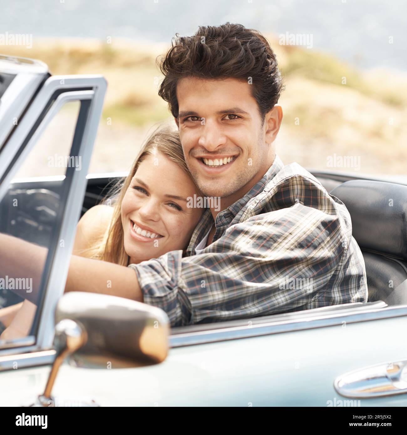 Happy to be driving together. An attractive young woman sitting next to ...