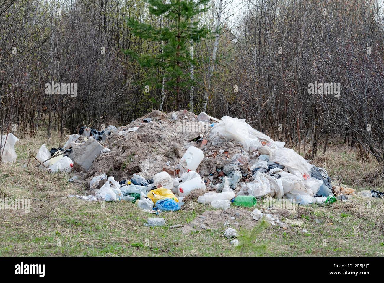 a large pile of garbage on the background of the forest. Environmental ...