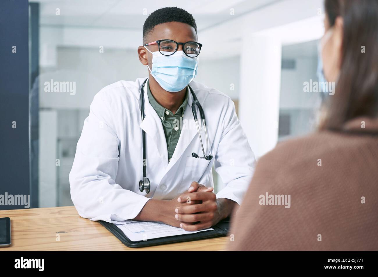 Focused on health and good rapport. a young doctor sitting with his ...