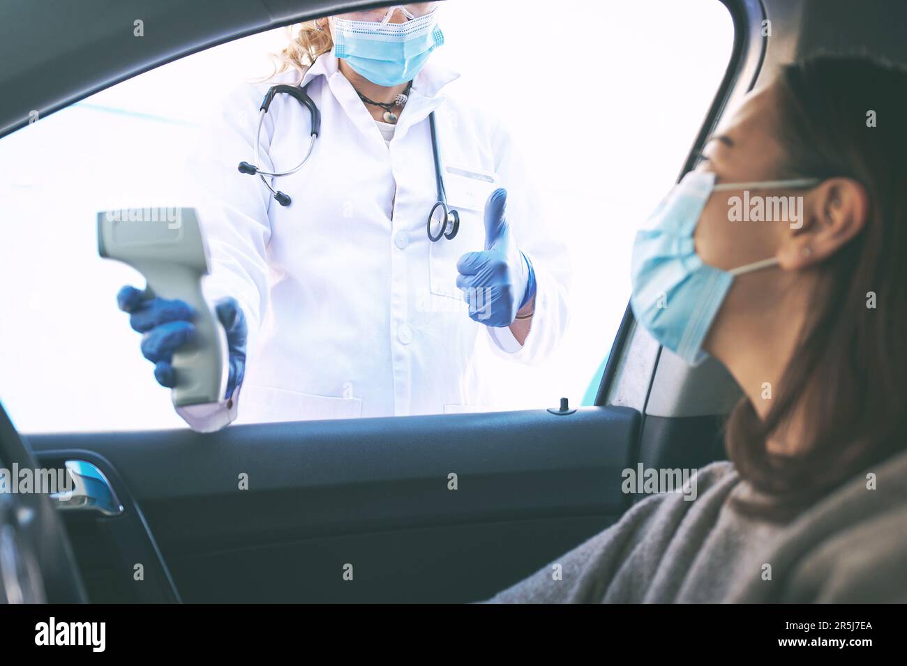 Your temperatures within normal range. a masked young woman getting her ...