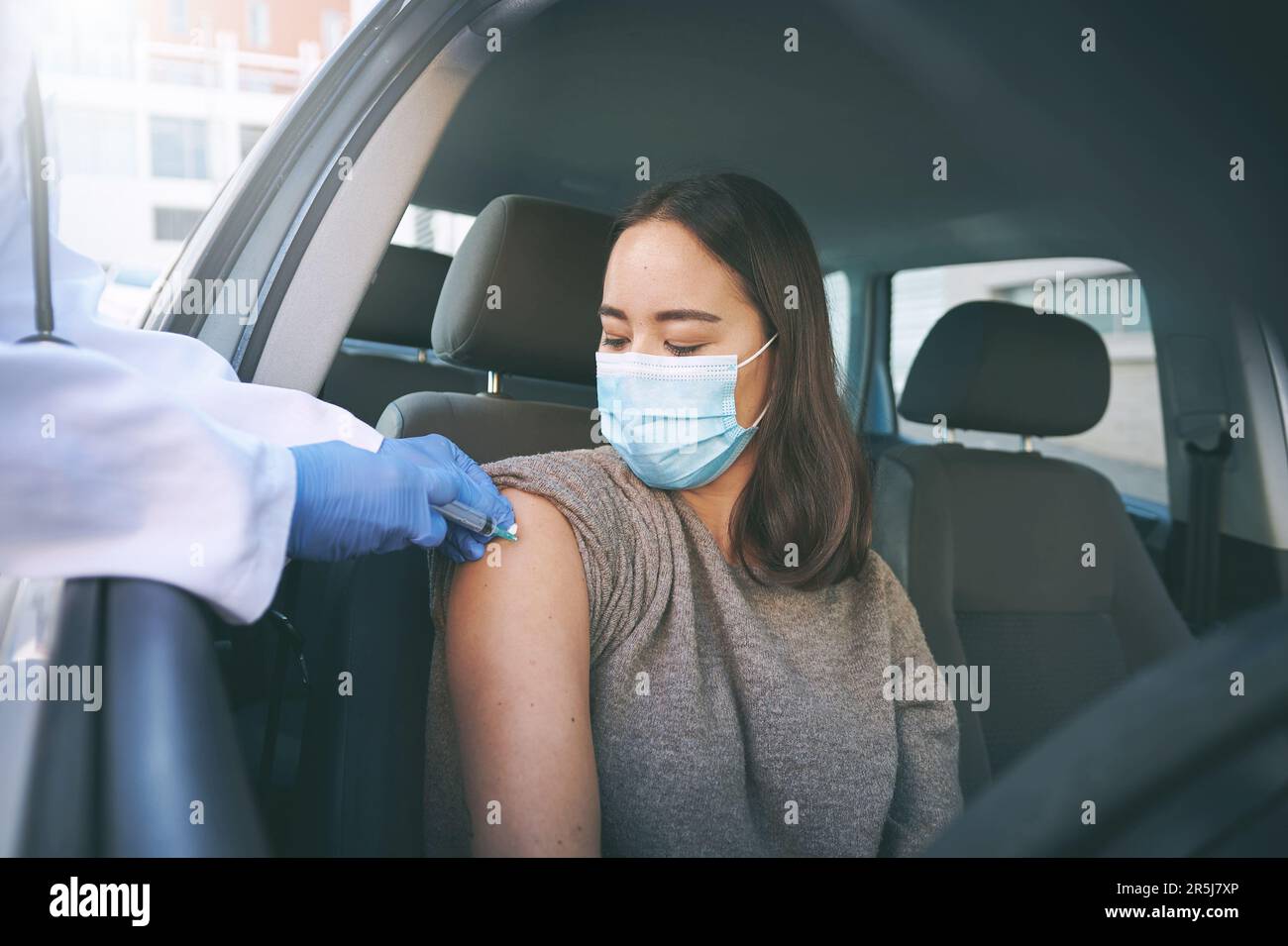 Prevent the spread, get vaccinated instead. a masked young woman ...
