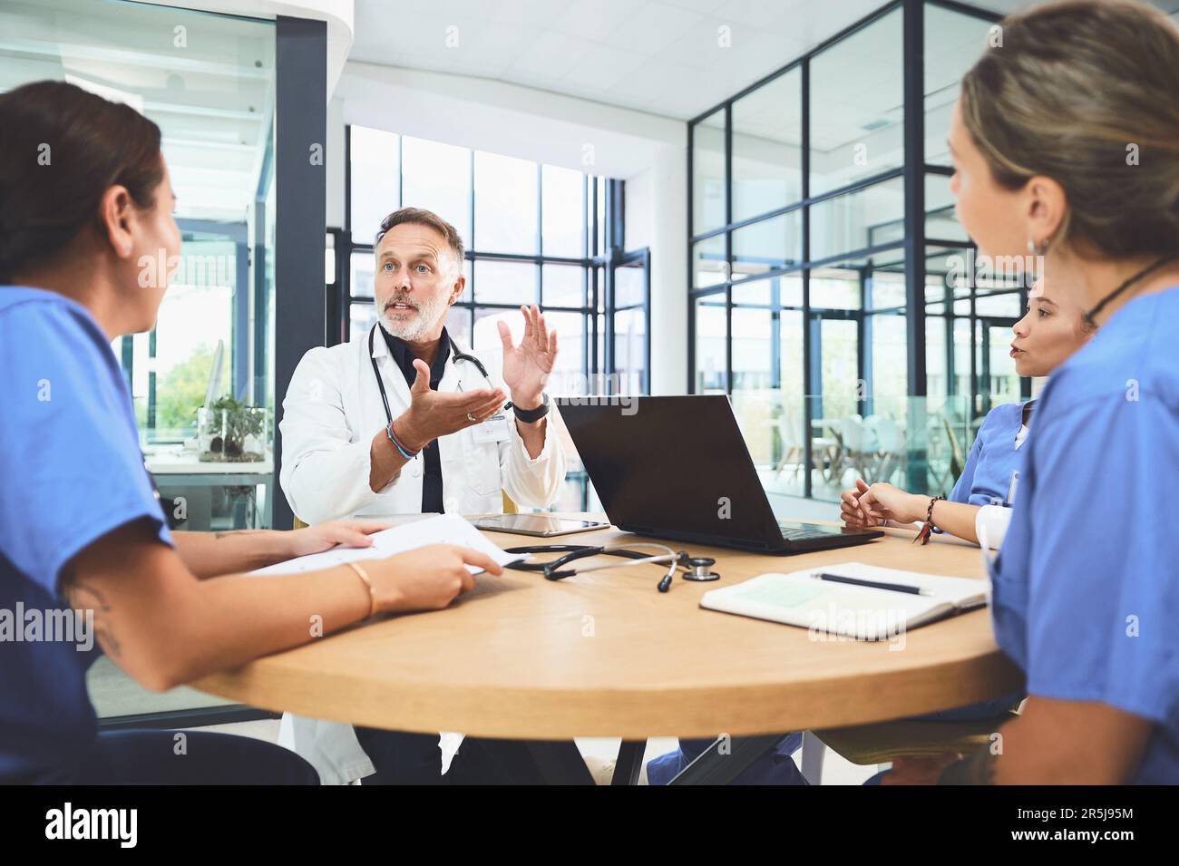 Making decisions regarding the treatment of their patients. a team of doctors having a meeting ...