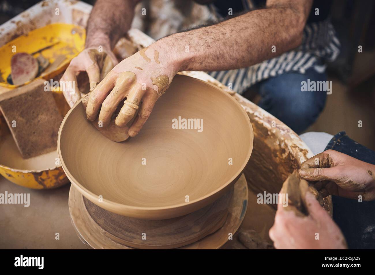 The ancient craft of molding clay. an unrecognisable man and woman ...