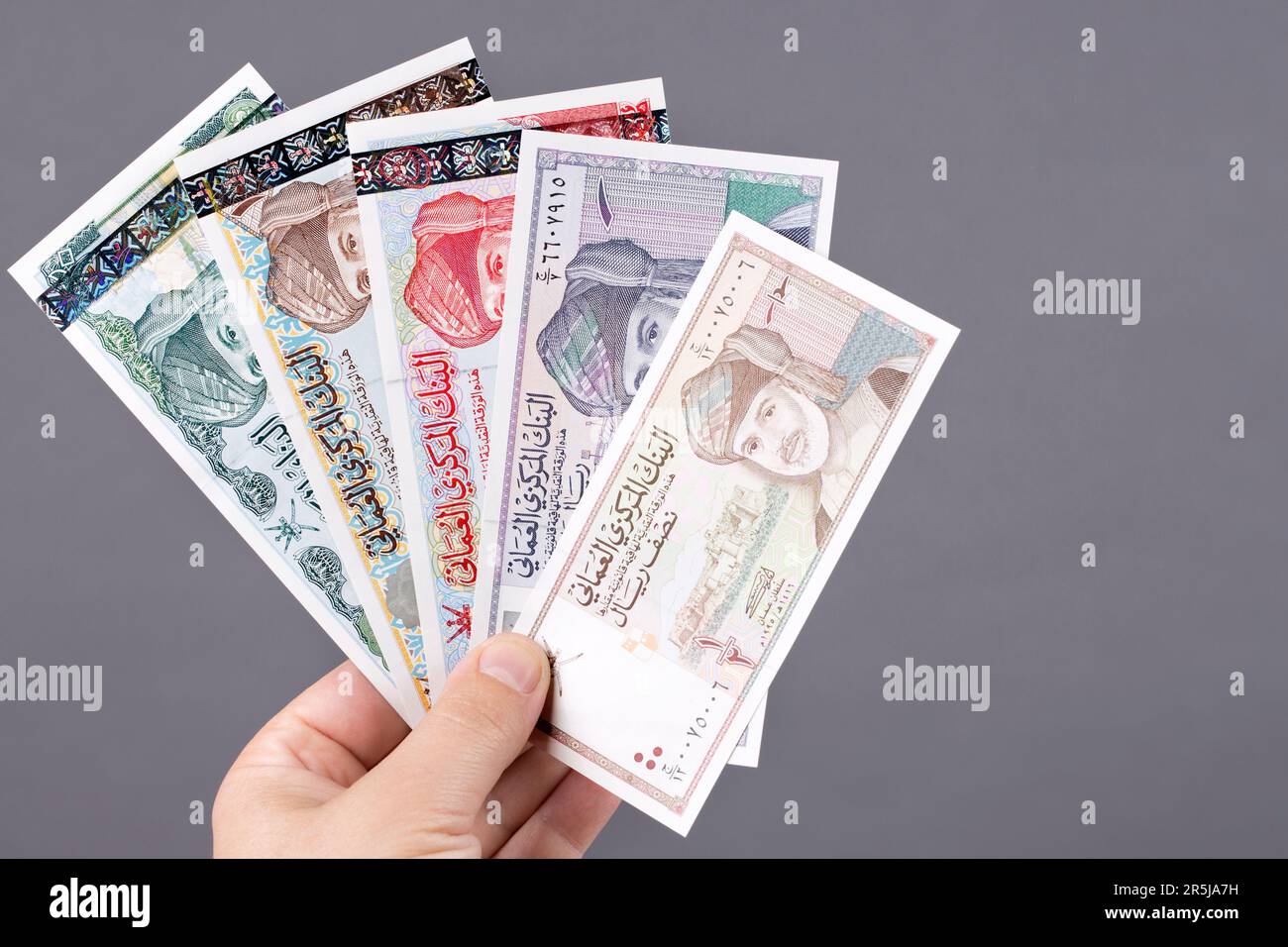 Old Omani money - rial in the hand on a gray background Stock Photo - Alamy