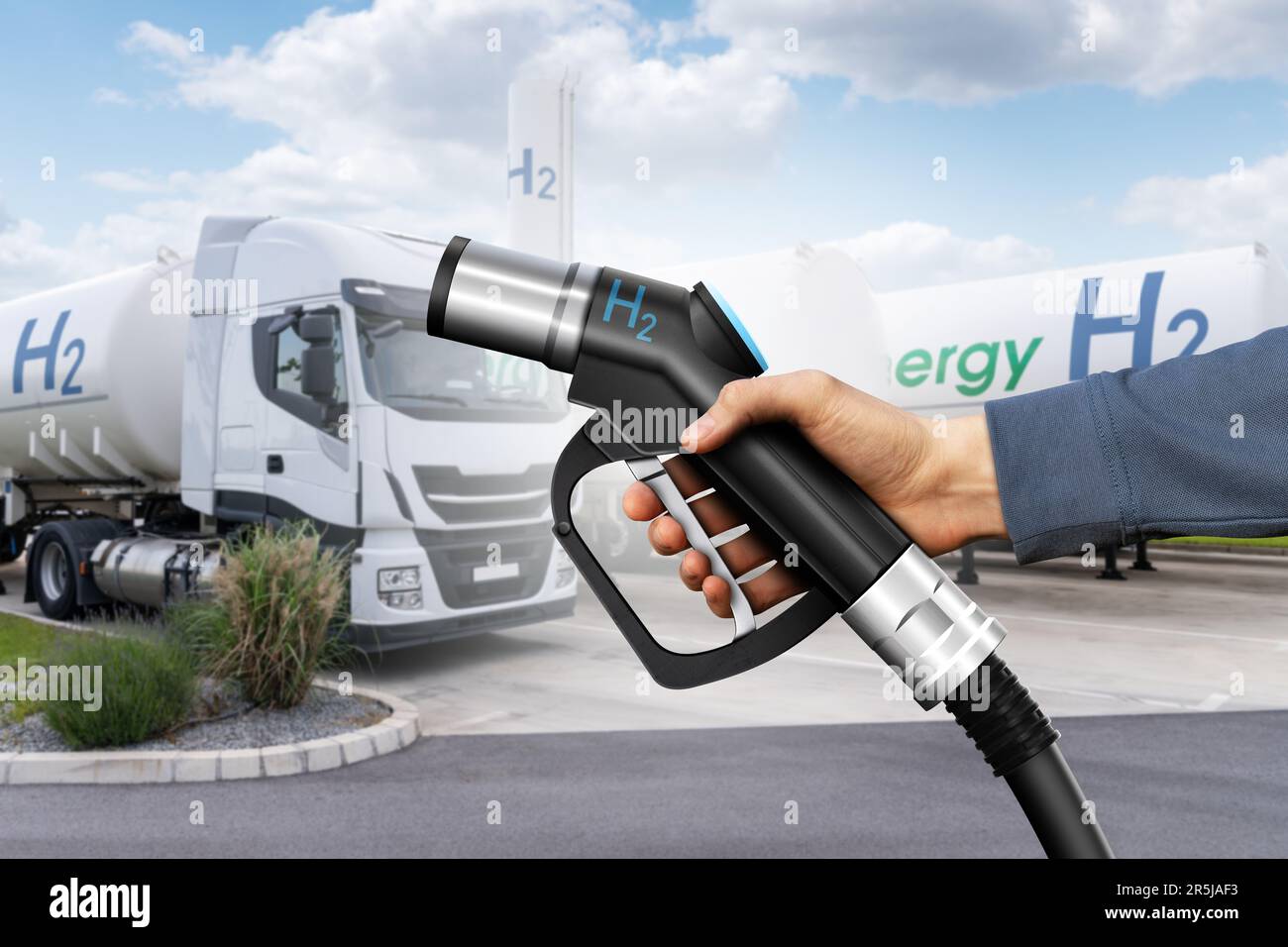 Hand with hydrogen fueling nozzle on a background of Hydrogen tank ...