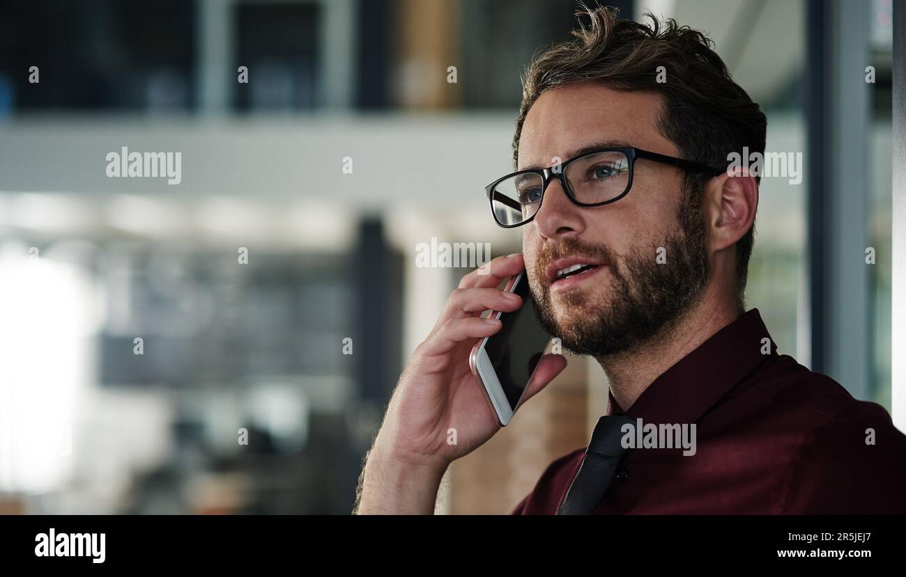 Make the call, make it happen. a young businessman using a mobile phone ...