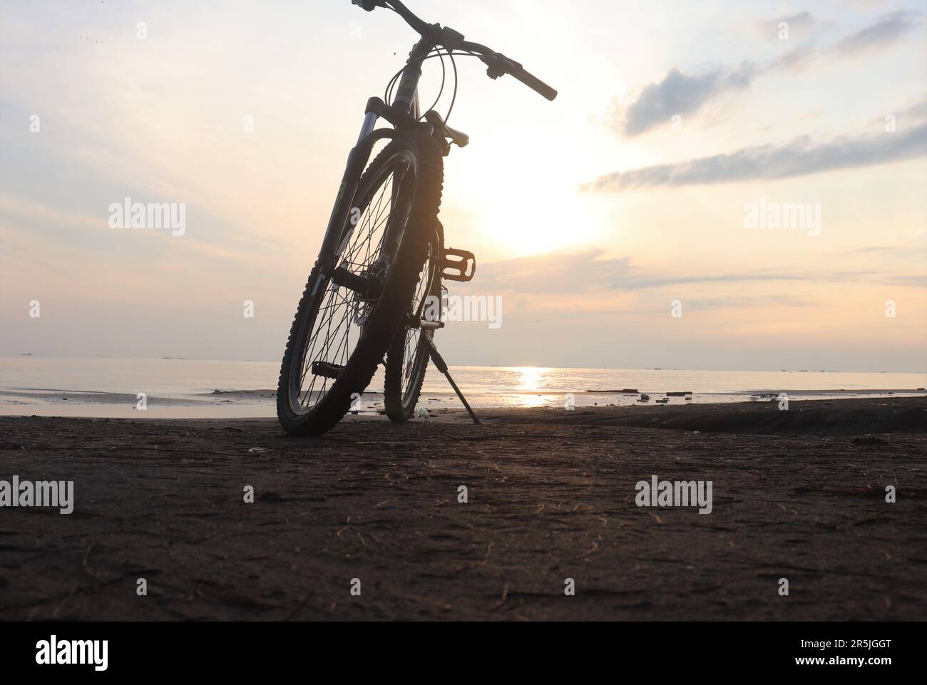 maintain health by cycling in the north coast of Java at sunrise Stock ...