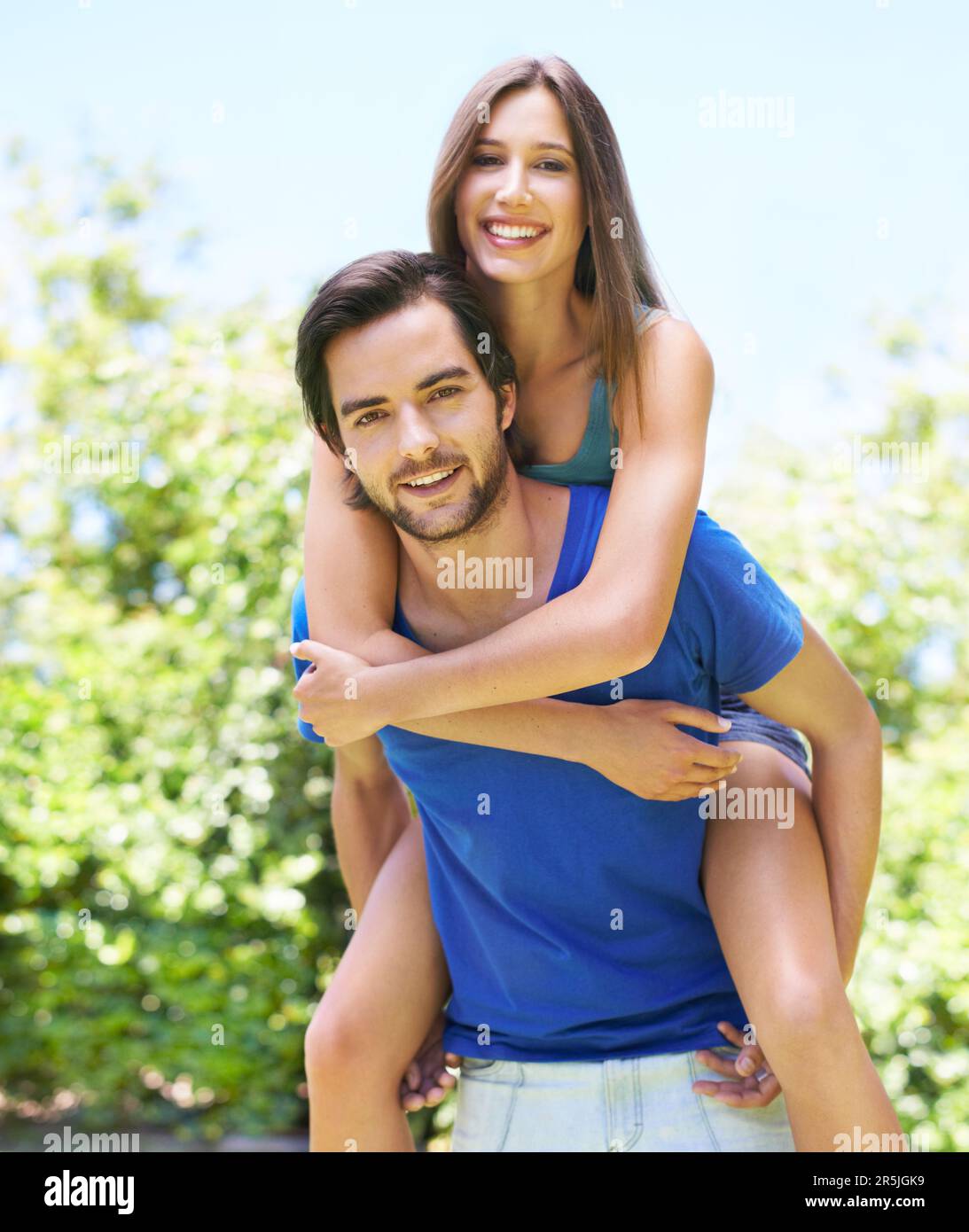 In love and happy. A smiling woman getting a piggyback from her ...